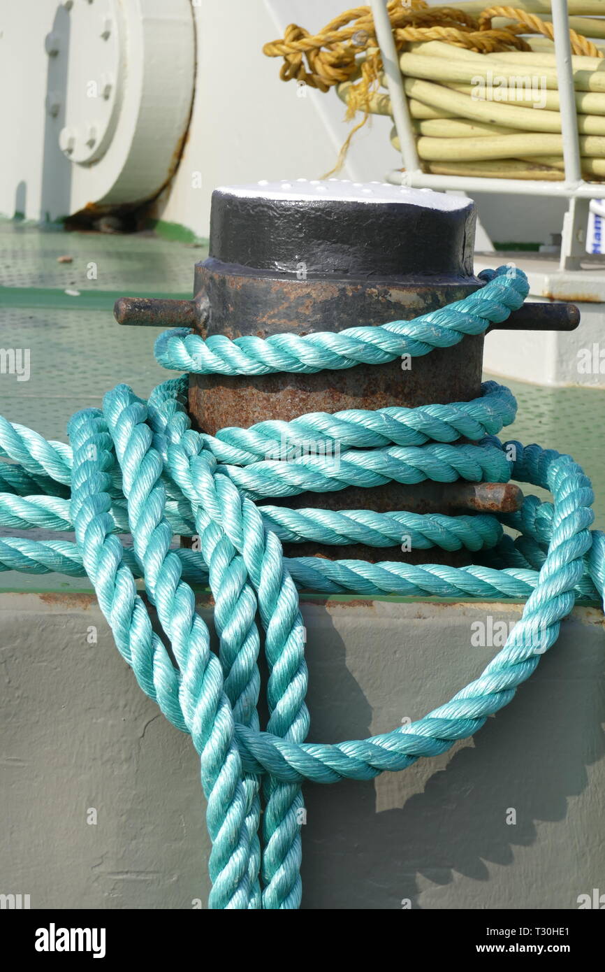 Knotted green ship rope on a bollard in the harbor Stock Photo - Alamy