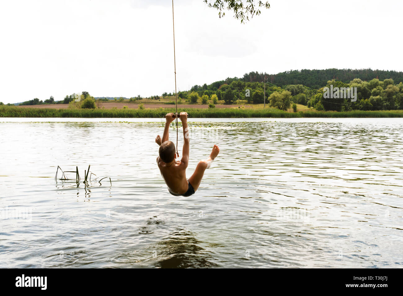 Child swinging rope river water hi-res stock photography and images - Alamy