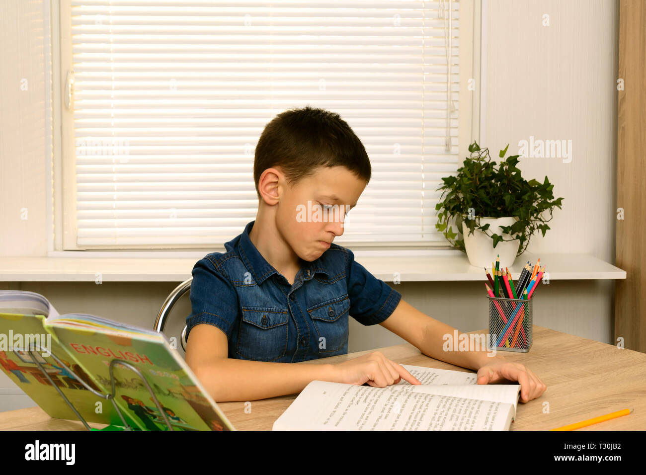 Young school boy studying at home. Boy doing homework in study room ...