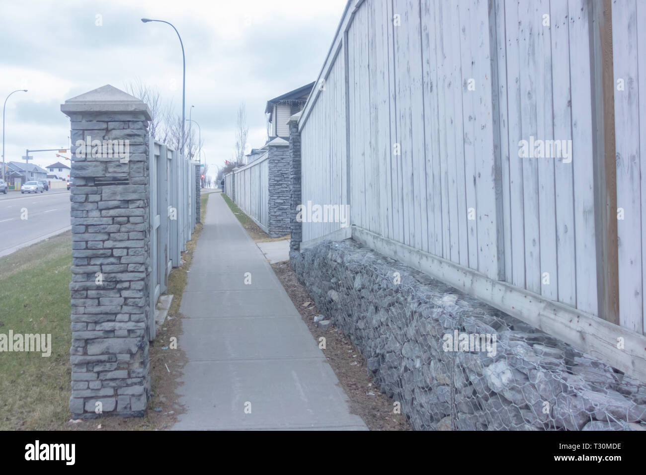 Wall beside pavement in suburban development Stock Photo - Alamy