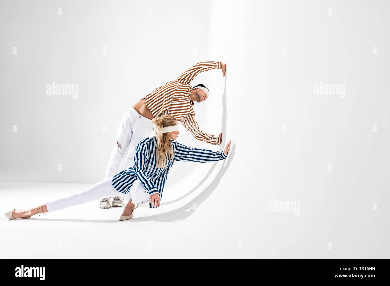 Nice poses. Models wearing white trousers and striped shirts and ...