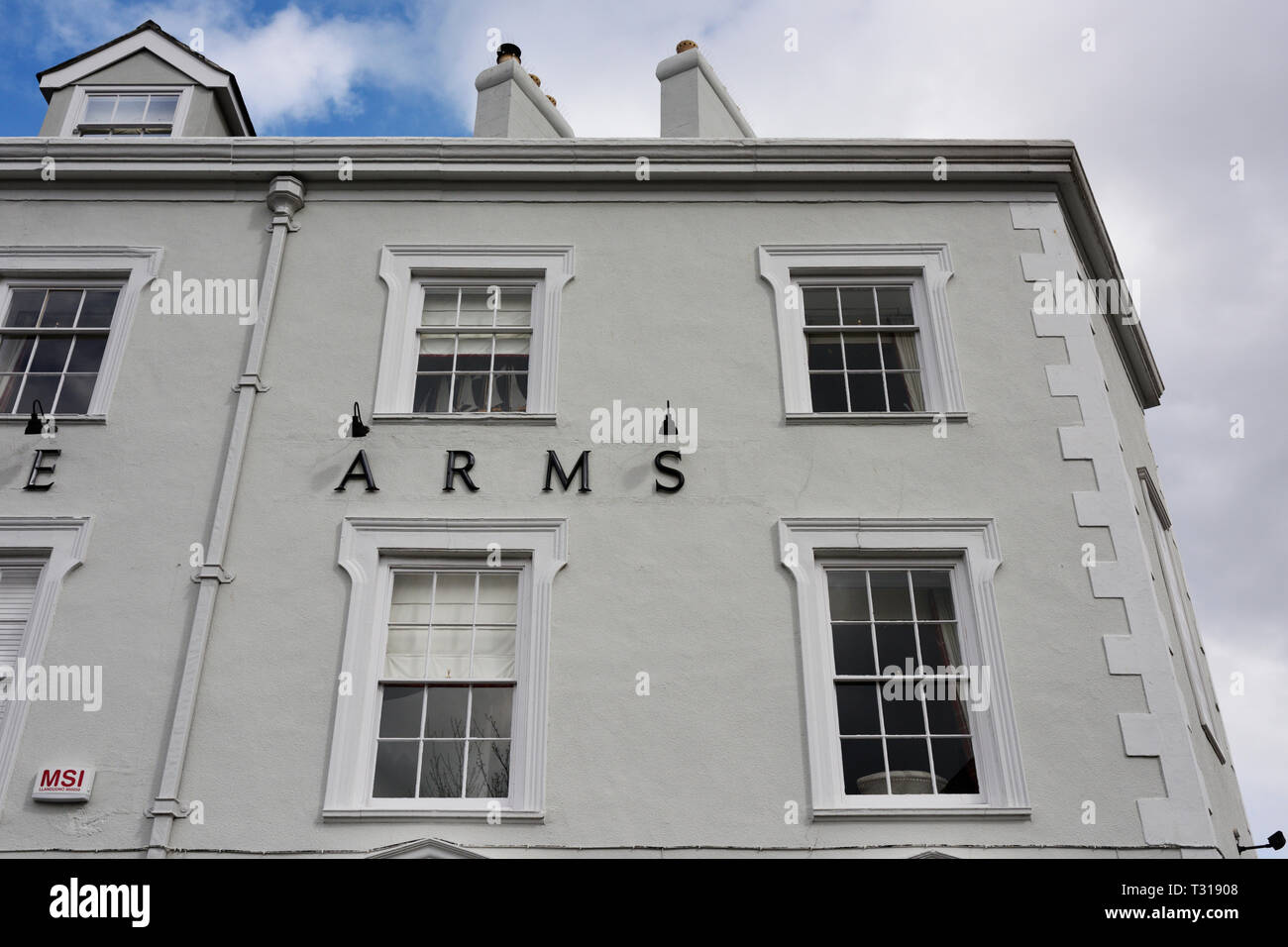 Pub wall with rendered wall, stone window surrounds and sash windows in ...