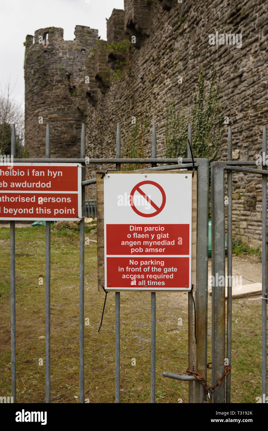 Two bilingual welsh and english warning signs on steel fencing at Conwy ...