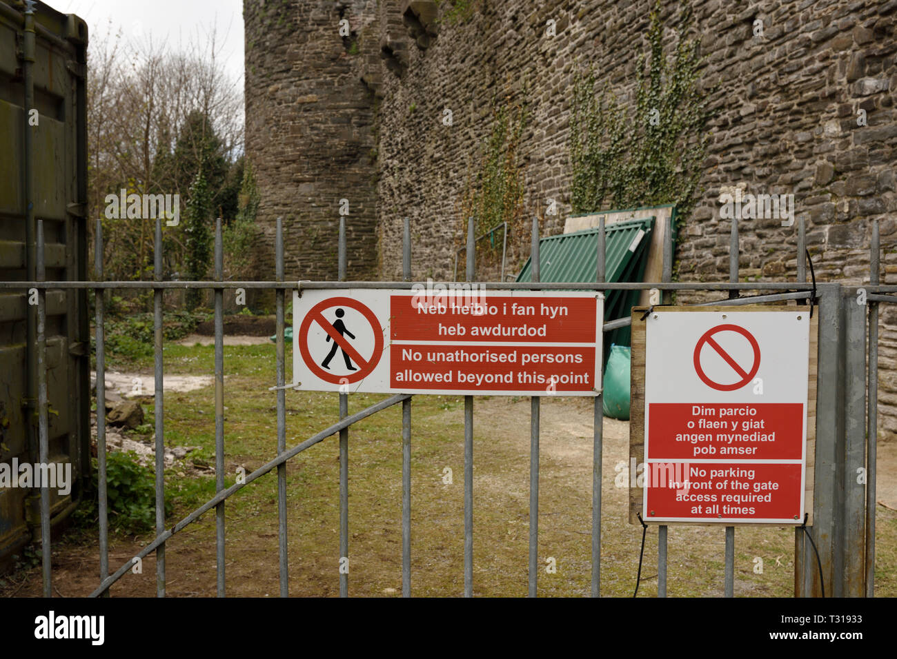 Two bilingual welsh and english warning signs on steel fencing at Conwy ...