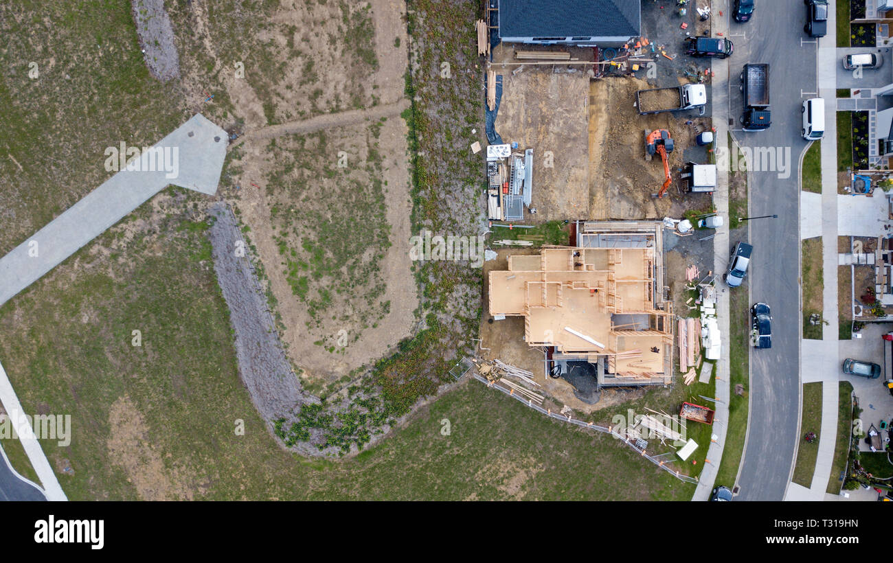 aerial view of a new suburb, a brand new house is building in progress ...