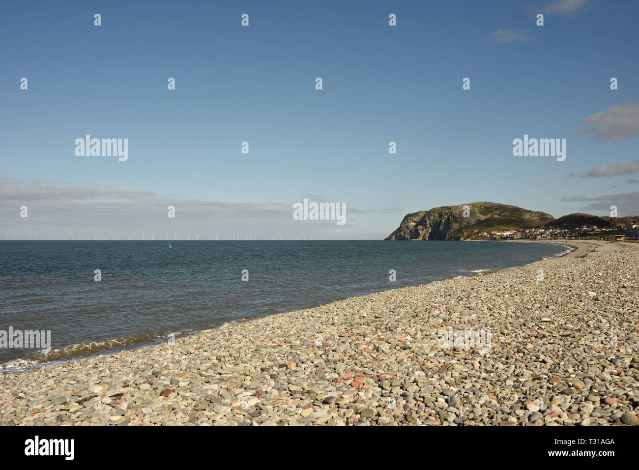 Shingle beach in Llandudno looking towards little orme in Conwy north ...