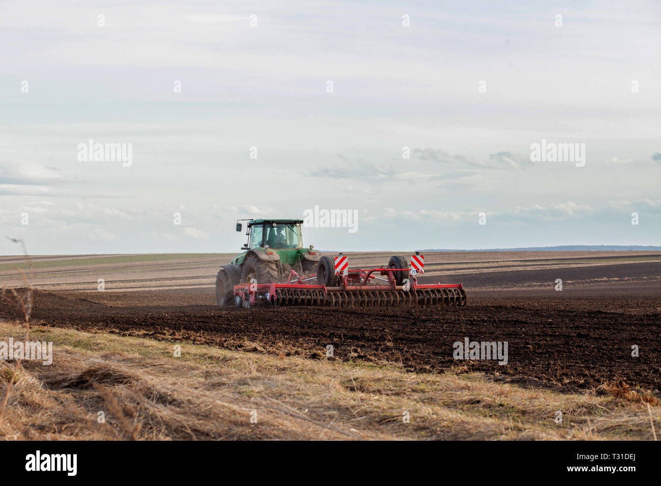 Agriculture,tractor preparing land with seedbed cultivator as part of ...