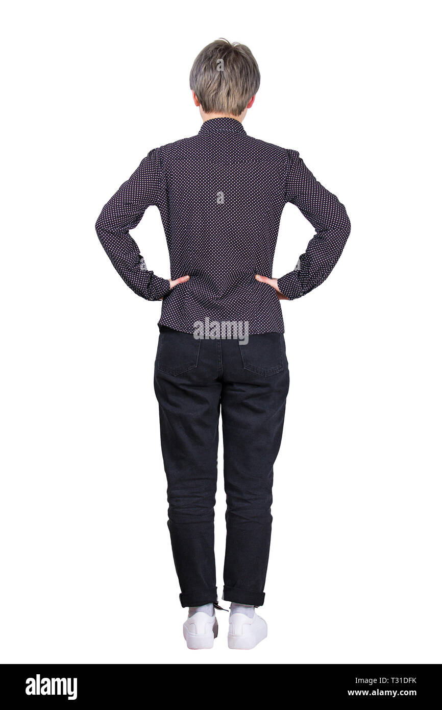Full length rear view of casual young woman holding hands on hips ...