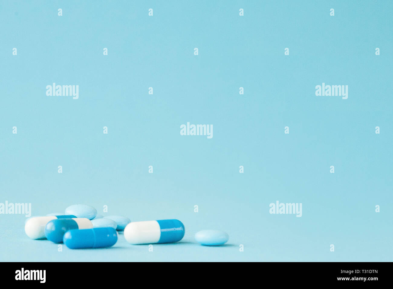 Blue pills and capsules on blue background with copy space Stock Photo ...