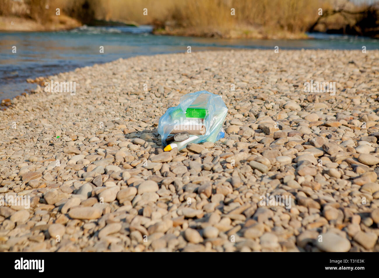 River pollution near the shore, garbage near the river, plastic food ...