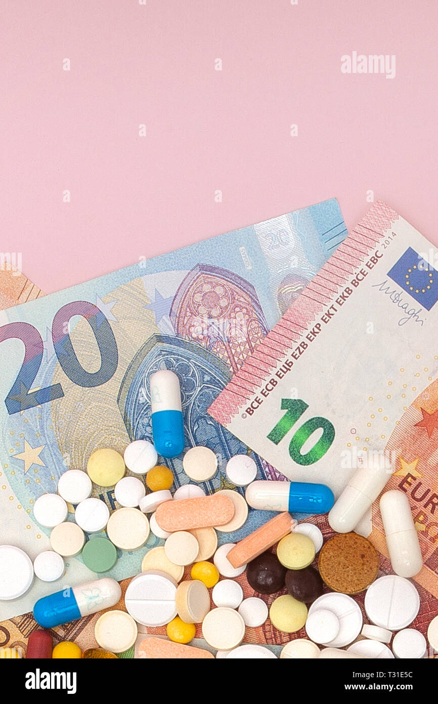 A pills and euro on a pink background with copy space. Soft focus ...