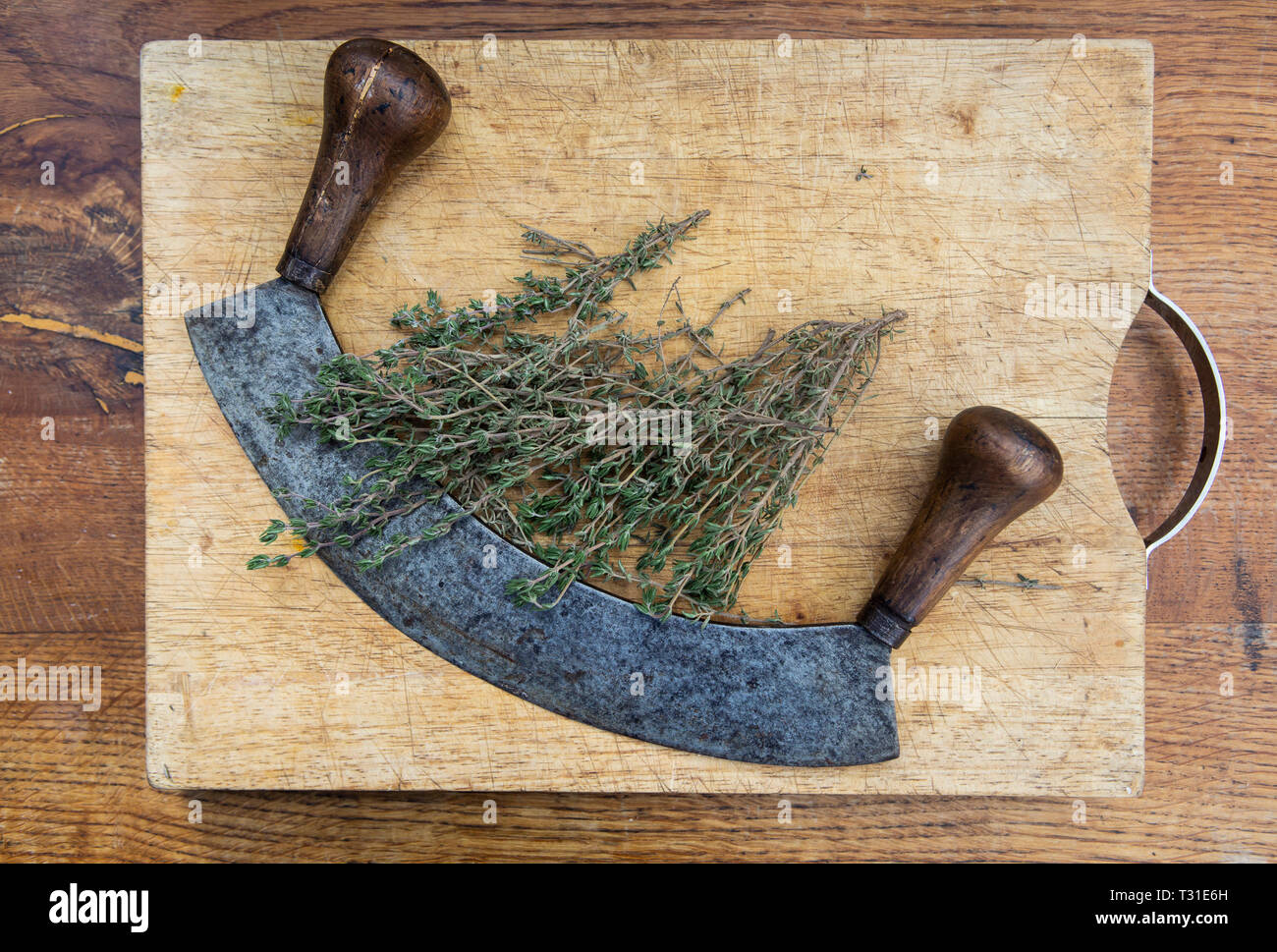 mezzaluna and wooden chopping board with fresh thyme Stock Photo - Alamy