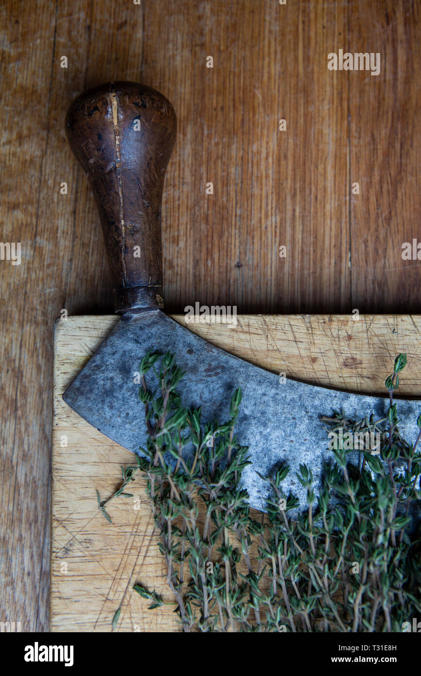 mezzaluna and wooden chopping board with fresh thyme Stock Photo - Alamy