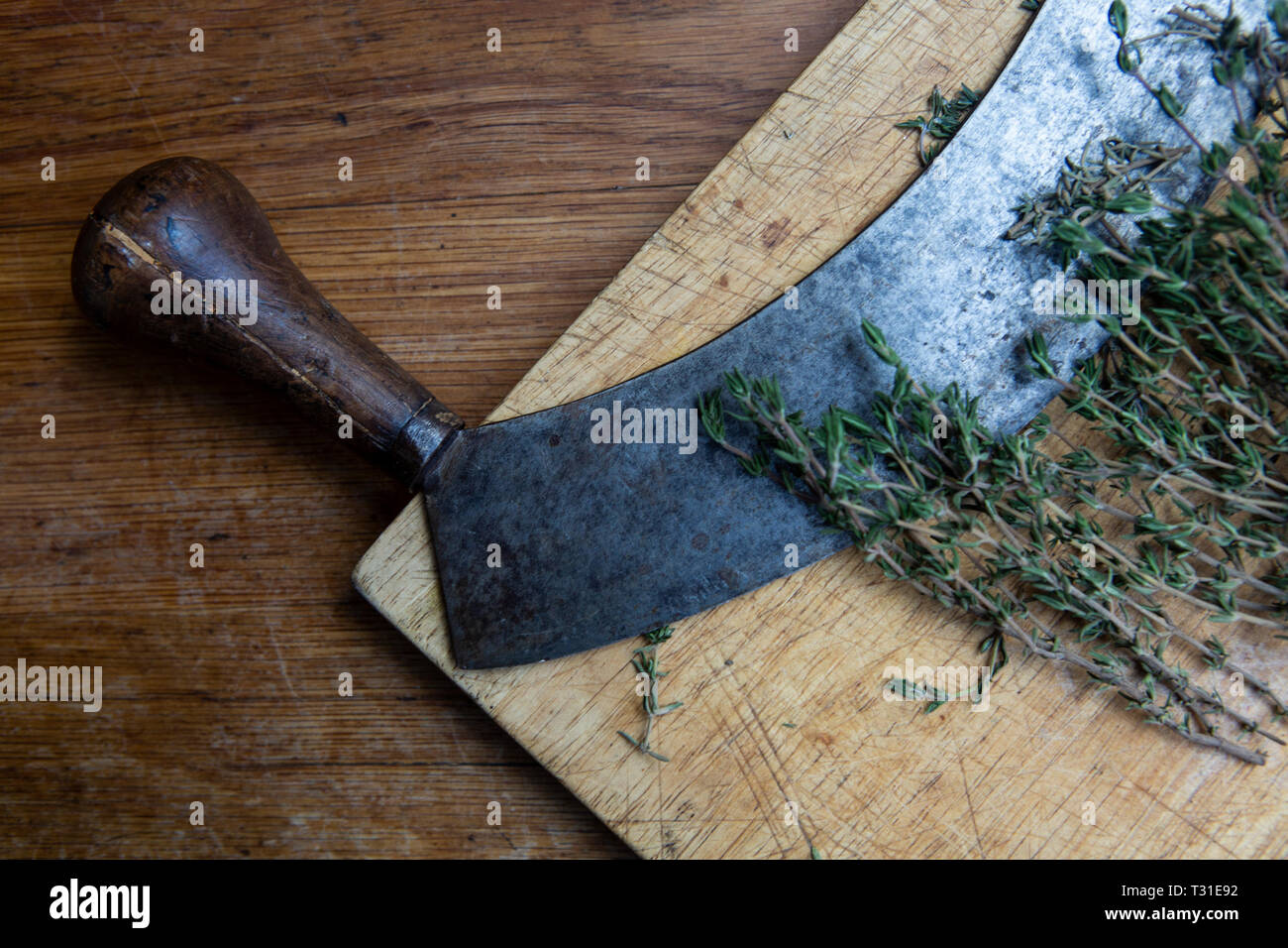 mezzaluna and wooden chopping board with fresh thyme Stock Photo - Alamy