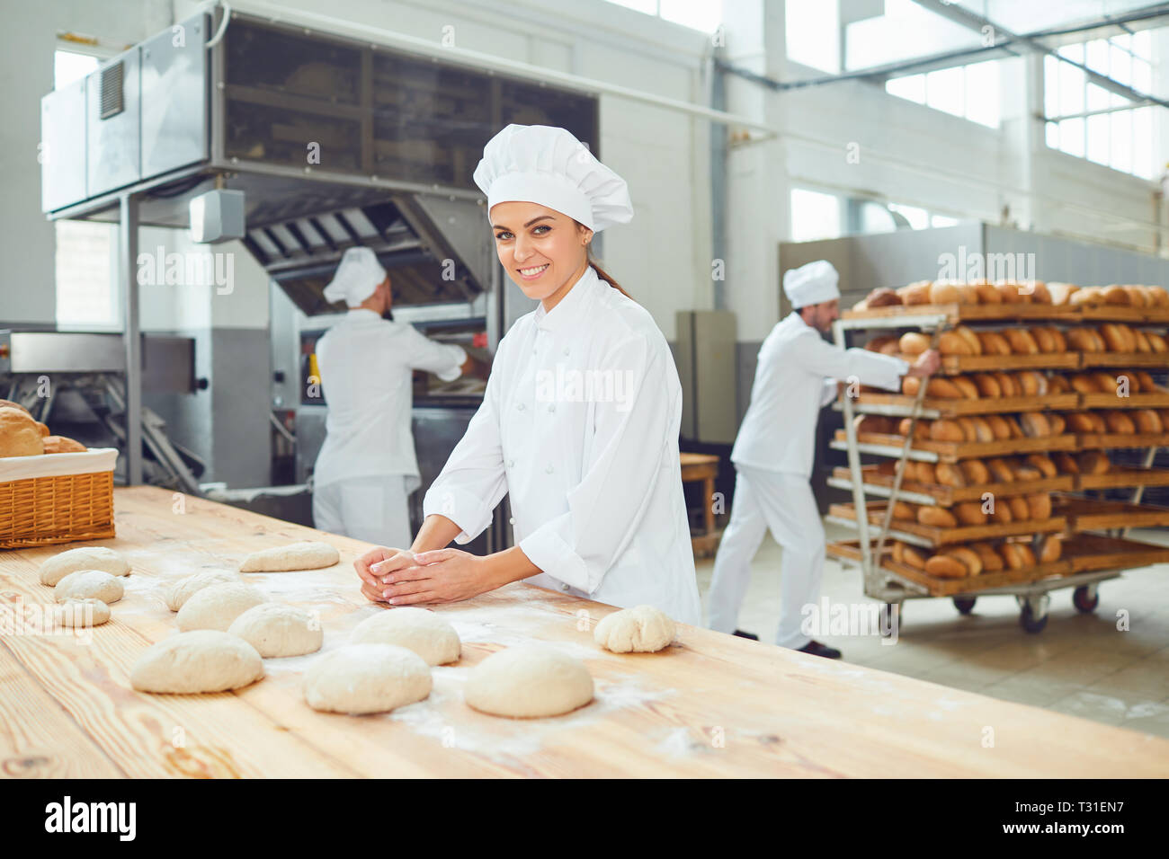 A woman baker smileswith colleagues at a bakery Stock Photo - Alamy