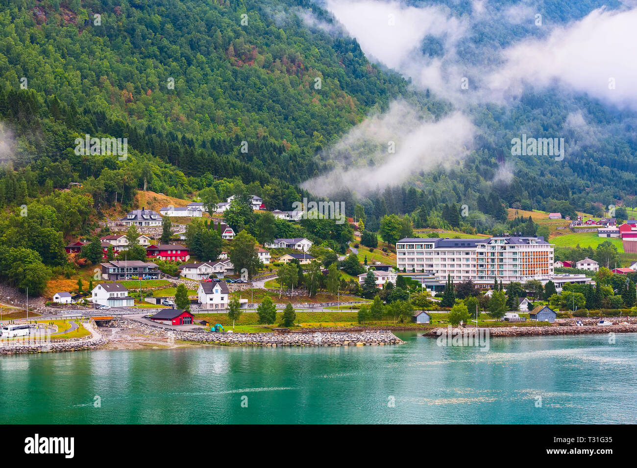 Norwegian fjord village landscape with low fog clouds, mountains and ...