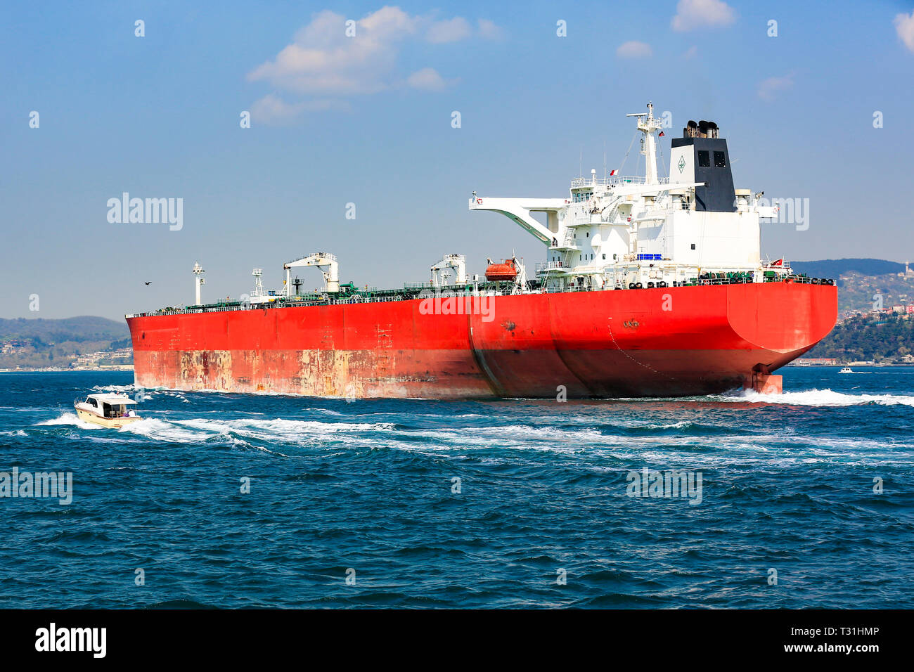 Giant Oil Tanker Sailing and Being Escorted by a Small Boat Stock Photo ...