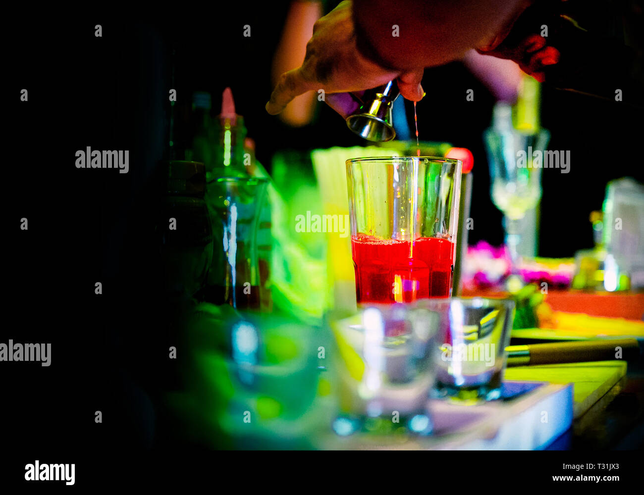 Bartender making alcohol cocktail at bar counter at nightclub, barman ...