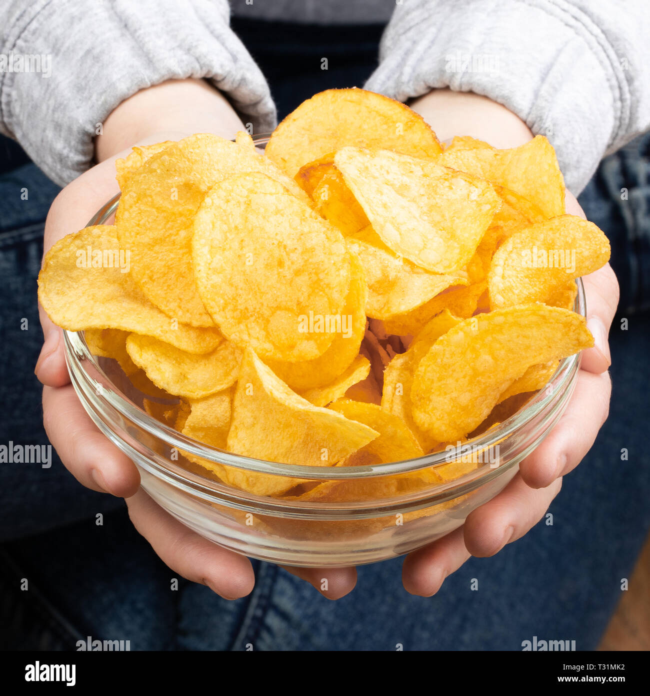 Female hand giving crispy potato chips bowl Stock Photo - Alamy
