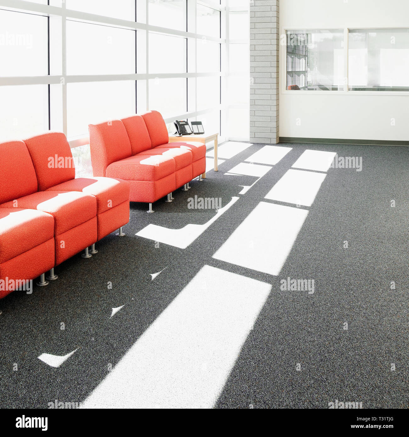 Sun shining through windows of empty lobby Stock Photo - Alamy