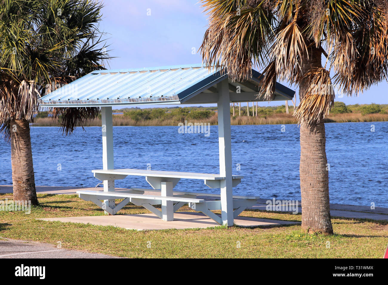Roadside covered picnic table beside a blue water background Stock ...
