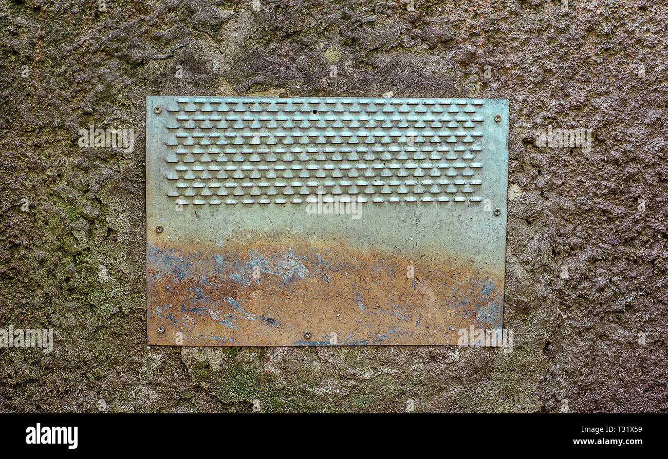 Rusty perforated air vents on concrete wall. Close-up Horizontal ...