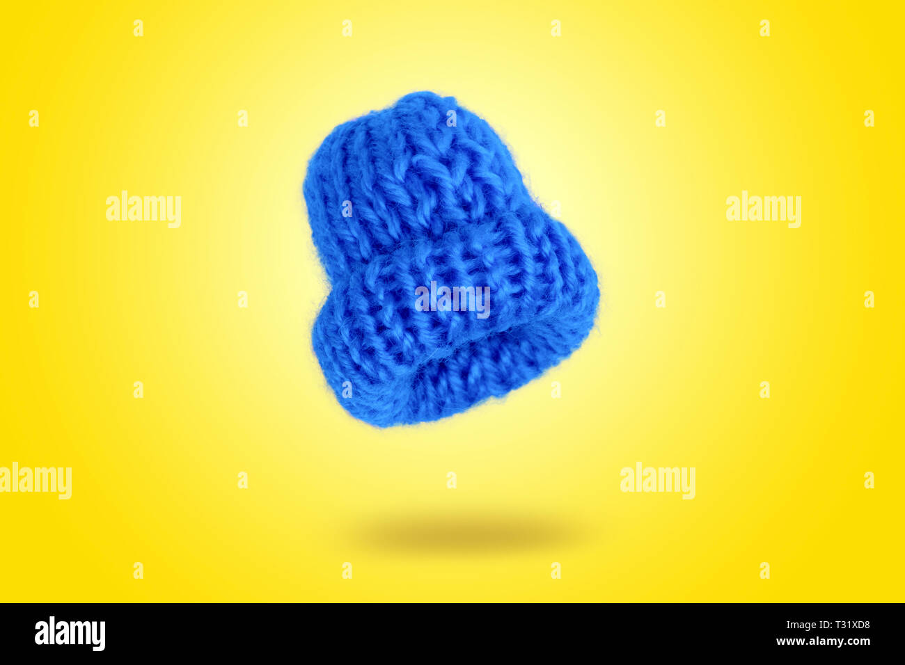 levitating blue knitted hat, image on a yellow background Stock Photo ...
