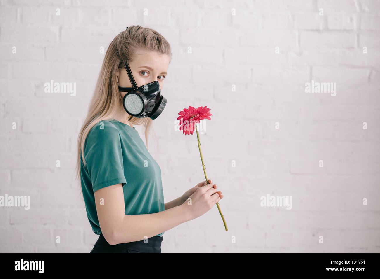 blonde girl with pollen allergy wearing respiratory mask and holding ...