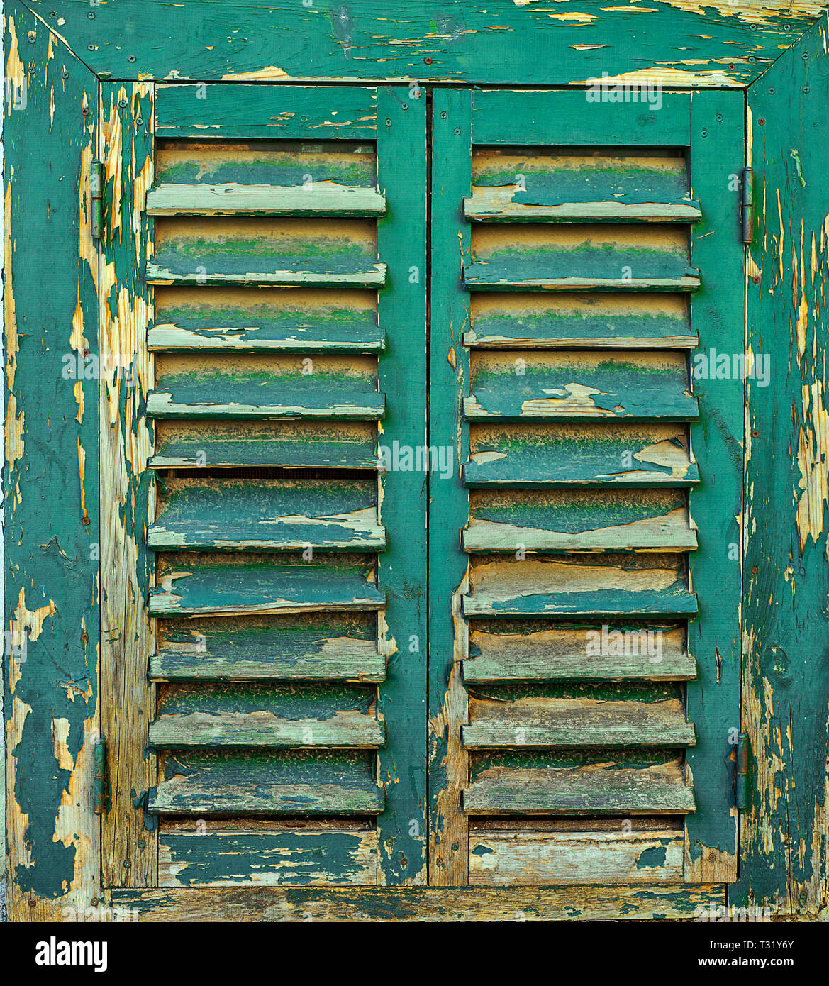 Green painted inclined plank window with cracked and scratch. Vertical ...