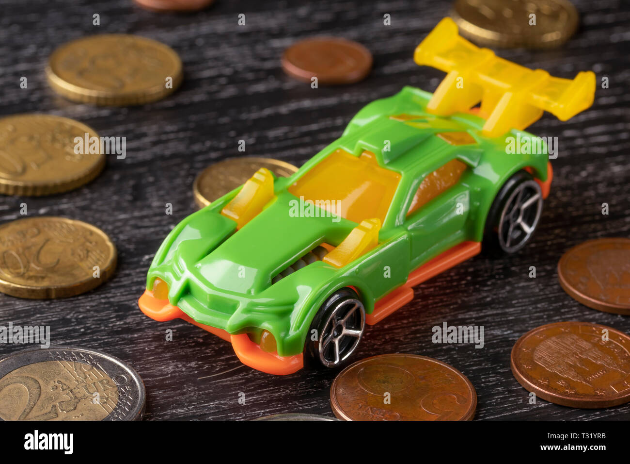 Euro car and euro toy on dark wooden background. The concept of ...
