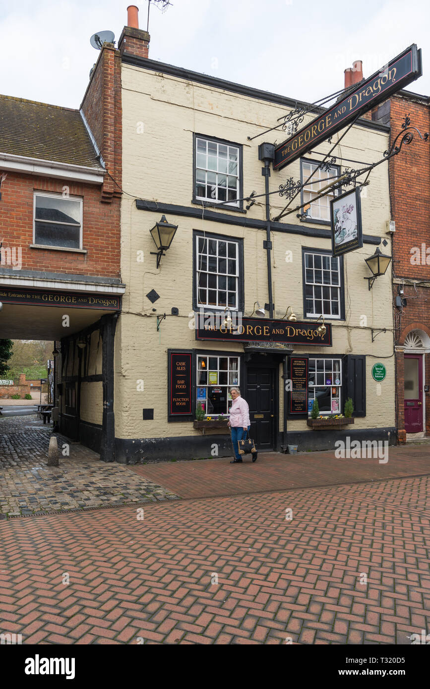 A lone elderly lady walking past the George and Dragon pub, High Street ...