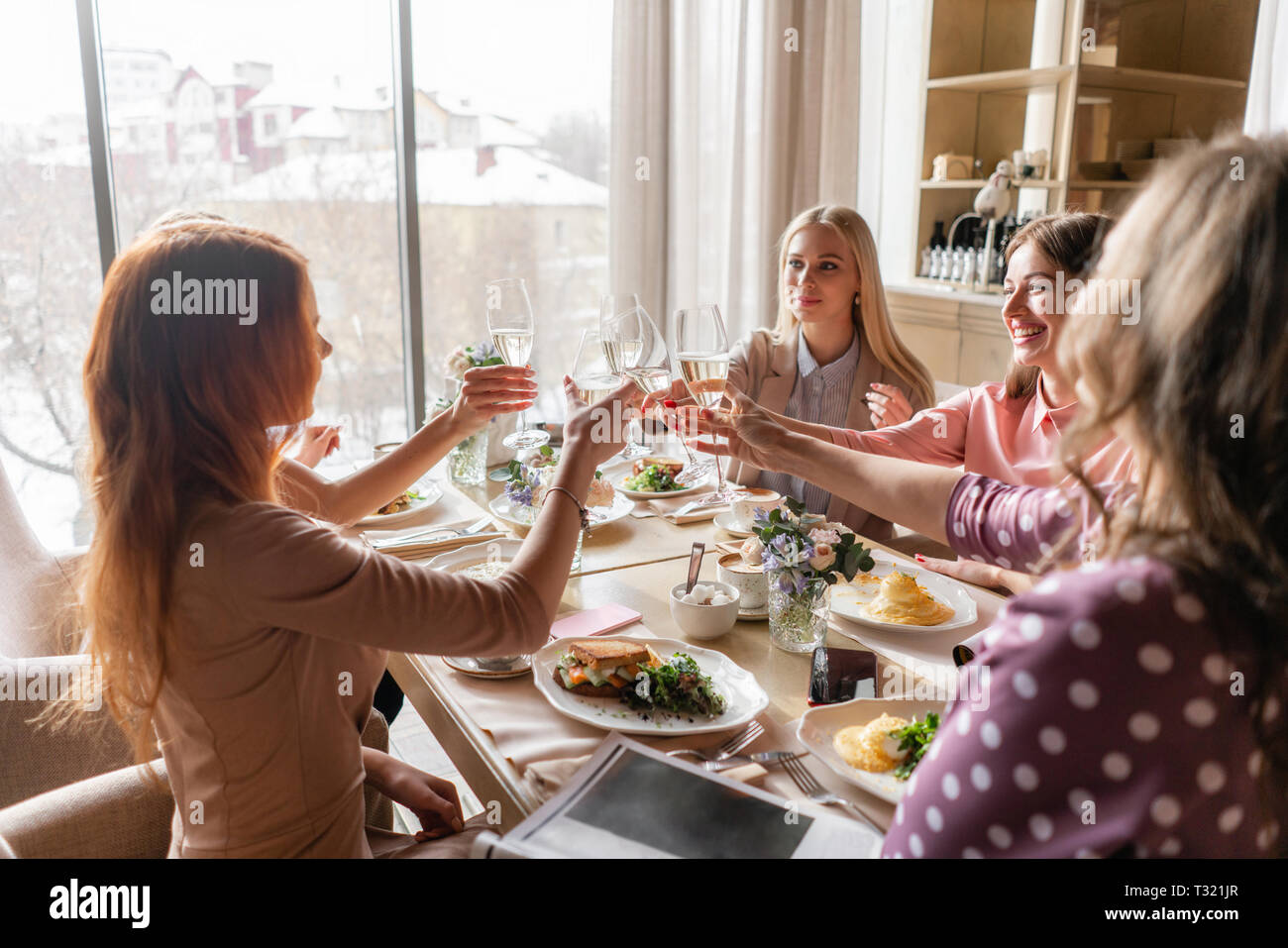 Five women. Portrait of young people having breakfast at table in ...
