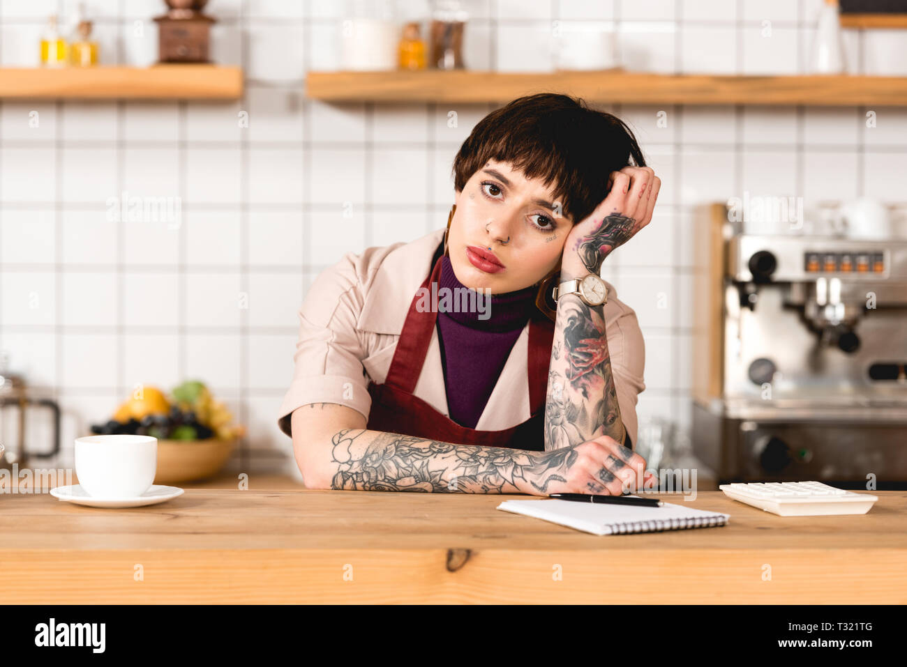 attractive, tired barista standing at bar counter in coffee shop Stock ...
