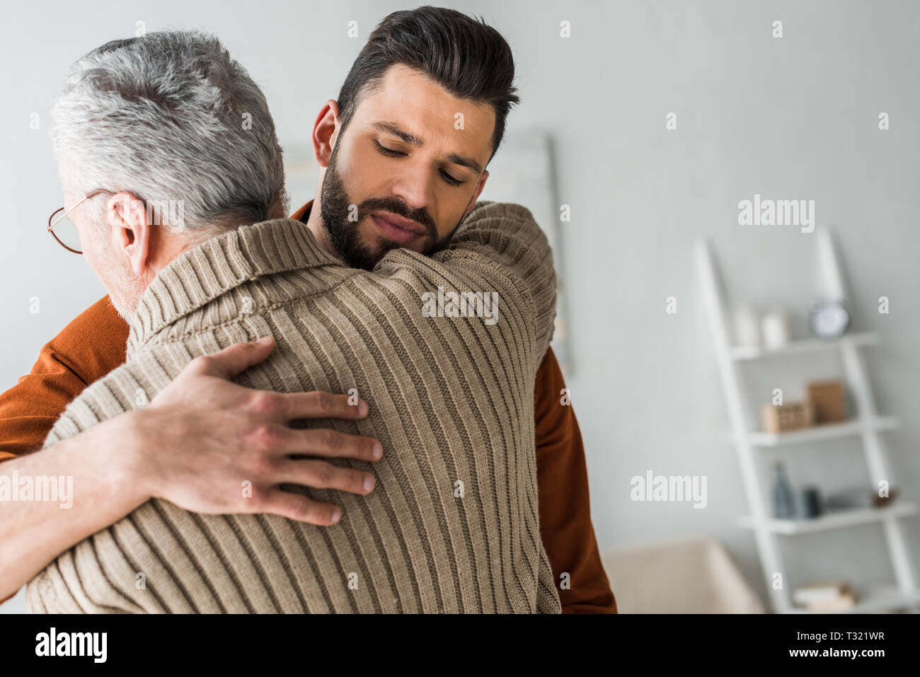 handsome bearded man hugging elder father at home Stock Photo - Alamy