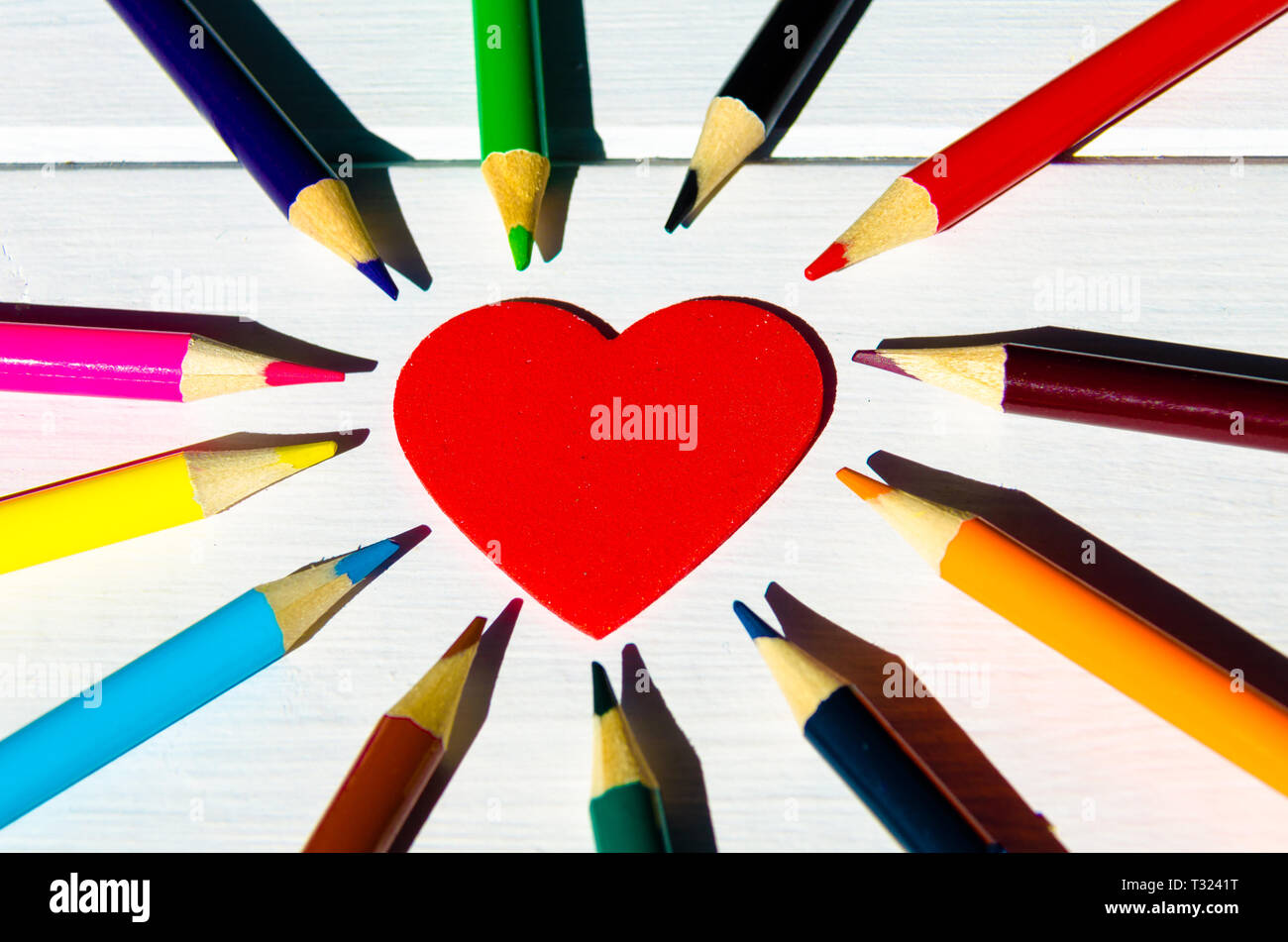 Colored pencils around a red heart Stock Photo - Alamy
