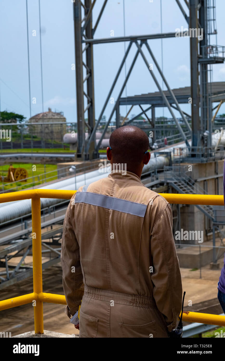 An oil worker looks out over the Punta Europa oil and gas complex in ...