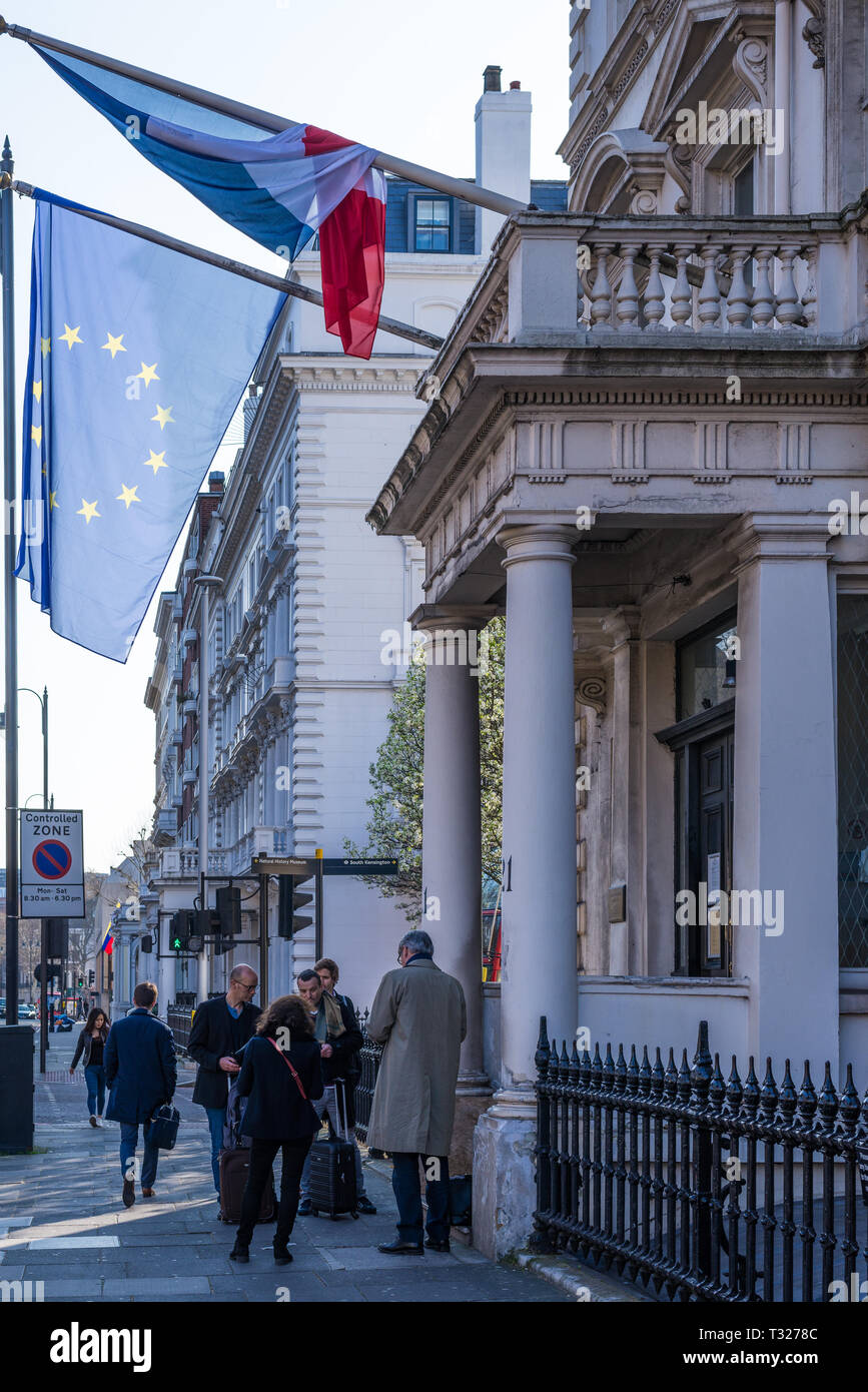 People wait outside the entrance to the French Consulate building ...