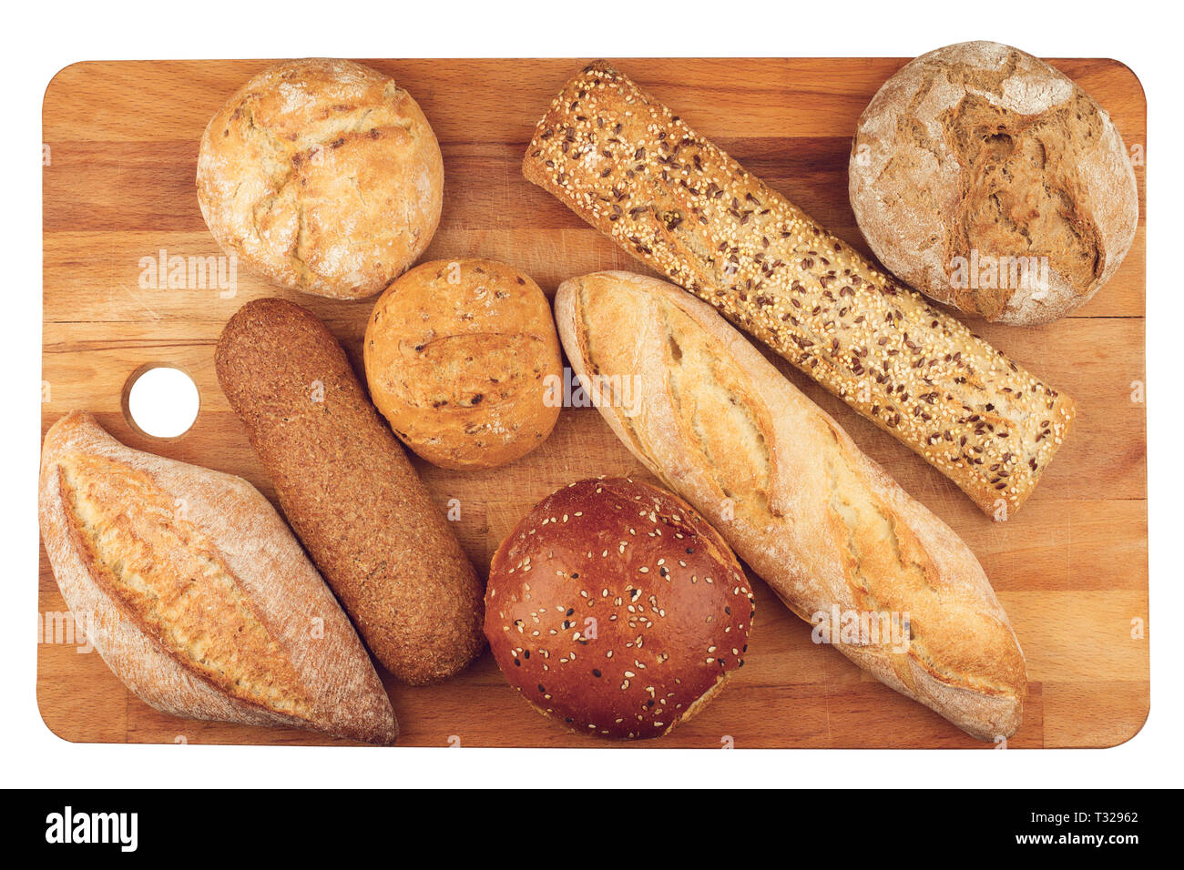 top view of different types of bread on wooden kitchen cutting board ...