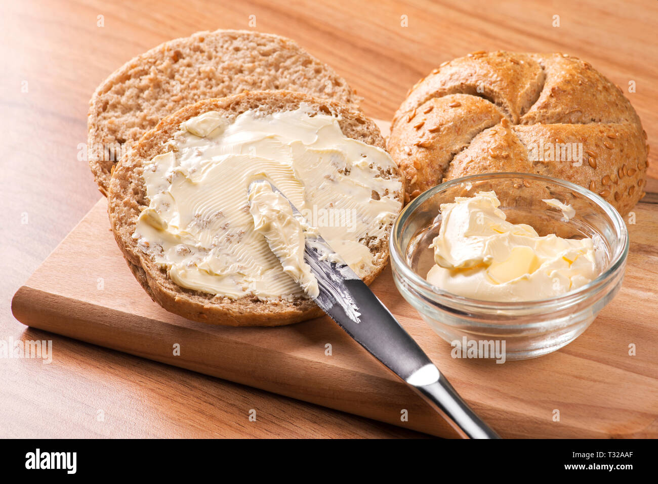 A knife spreading butter on bread Stock Photo - Alamy