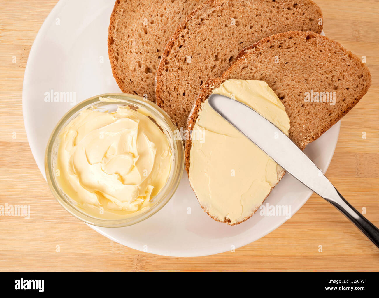 A knife spreading butter on bread Stock Photo - Alamy