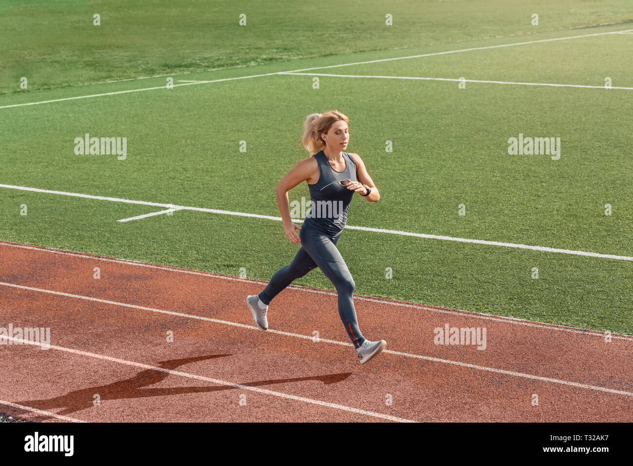 Young woman athlete on stadium sporty lifestyle running on track ...