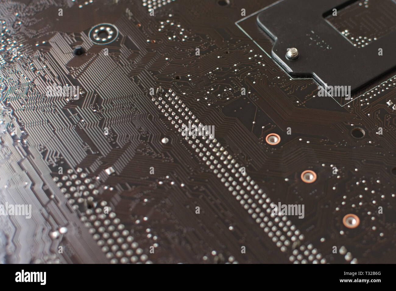 Modern computer ATX format motherboard. Soldering points and conductive ...