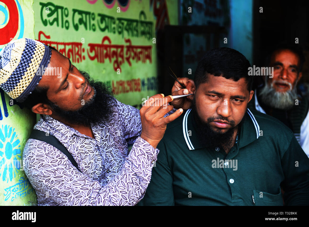 Traditional Earwax cleaner with his customer Stock Photo - Alamy
