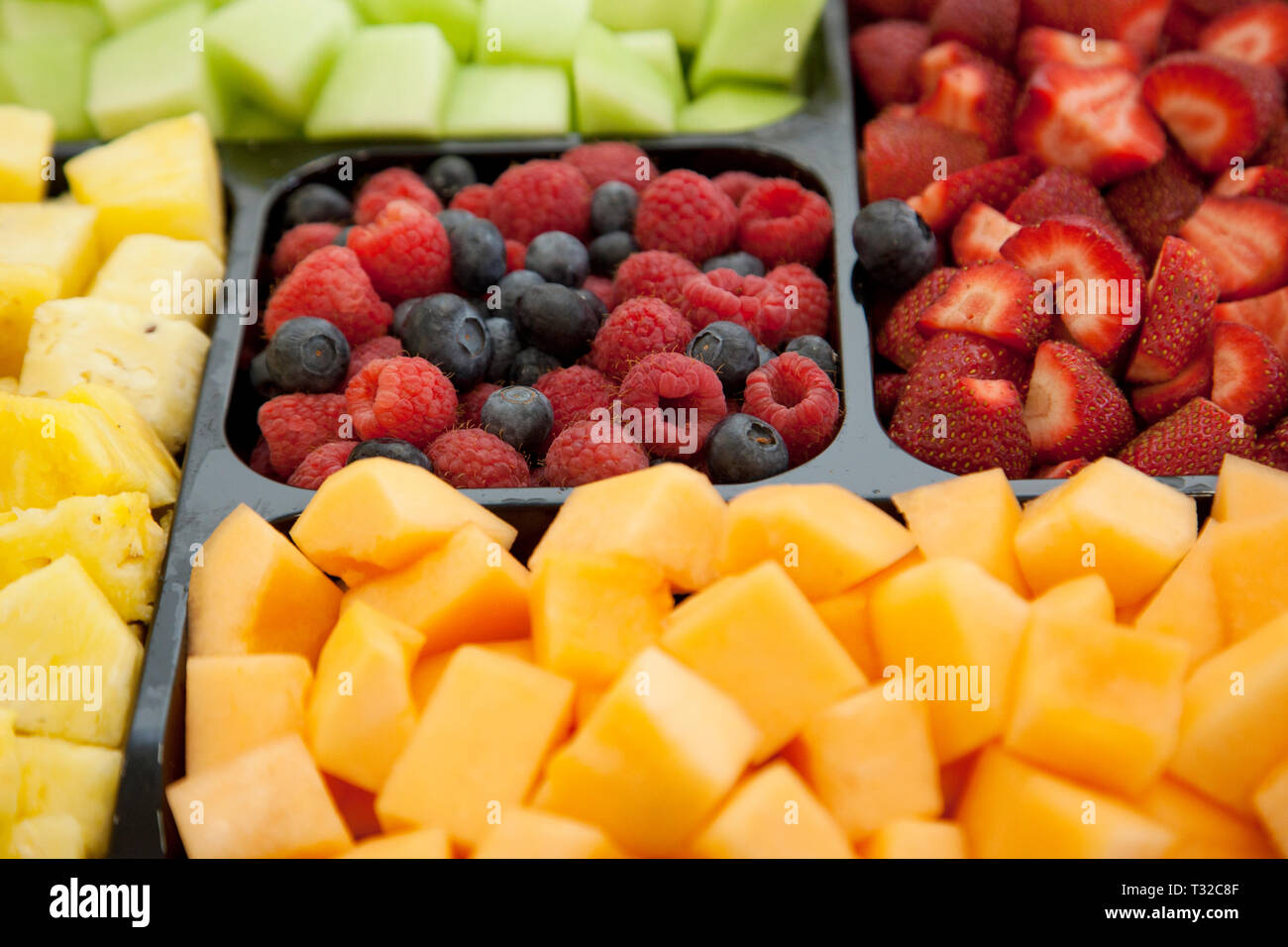 Tray of cut melons and berries Stock Photo - Alamy