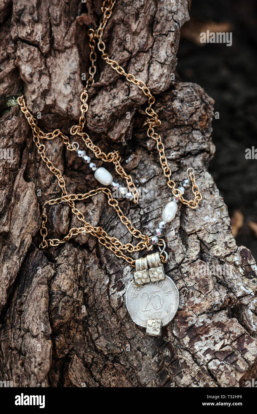 Handmade pendant from original coin on golden chain Stock Photo - Alamy