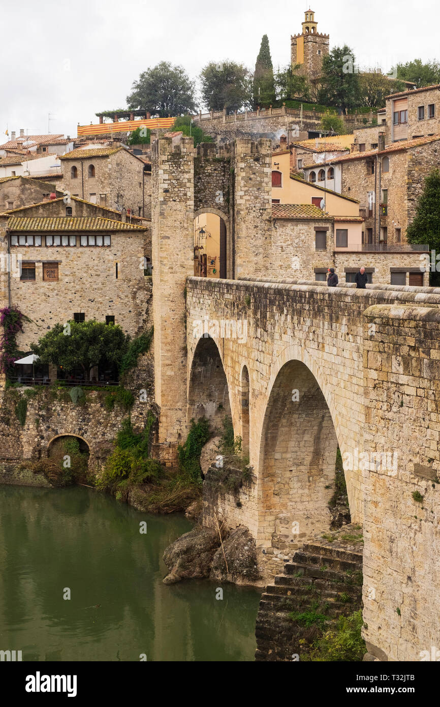 The Fluvià river flows under the arches of the medieval bridge of ...