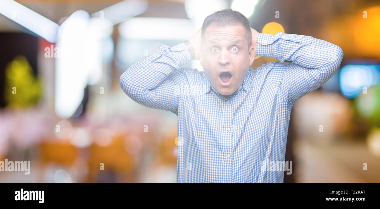 Middle age arab business man over isolated background Crazy and scared ...