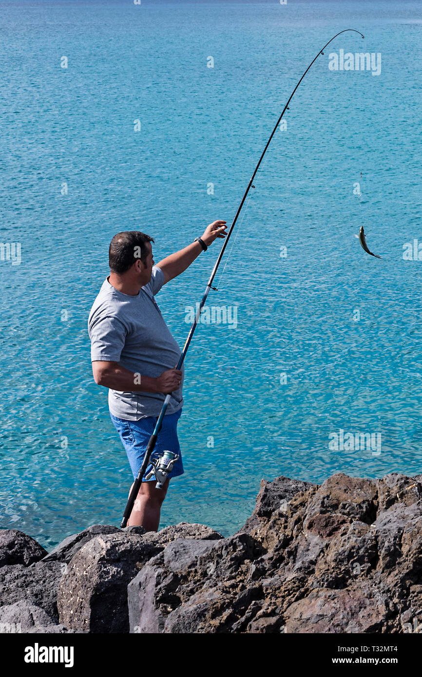 Fisherman capturing a fish Stock Photo - Alamy