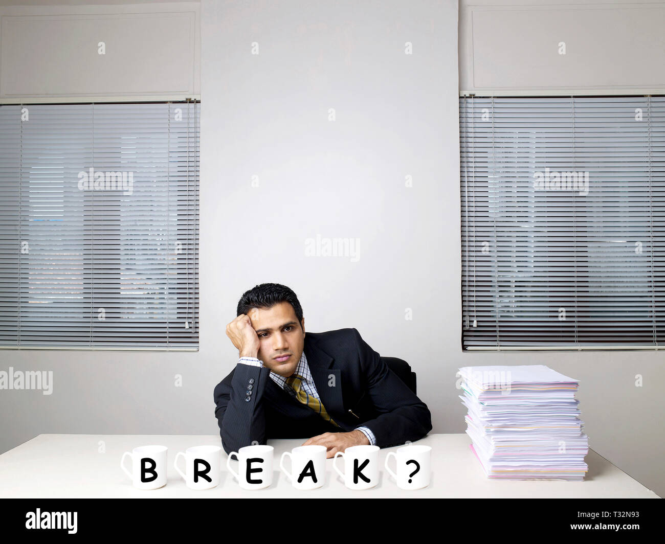 MAN DREAMING OF A GETTING A BREAK FROM BIG WORK LOAD WITH STACKS OF ...