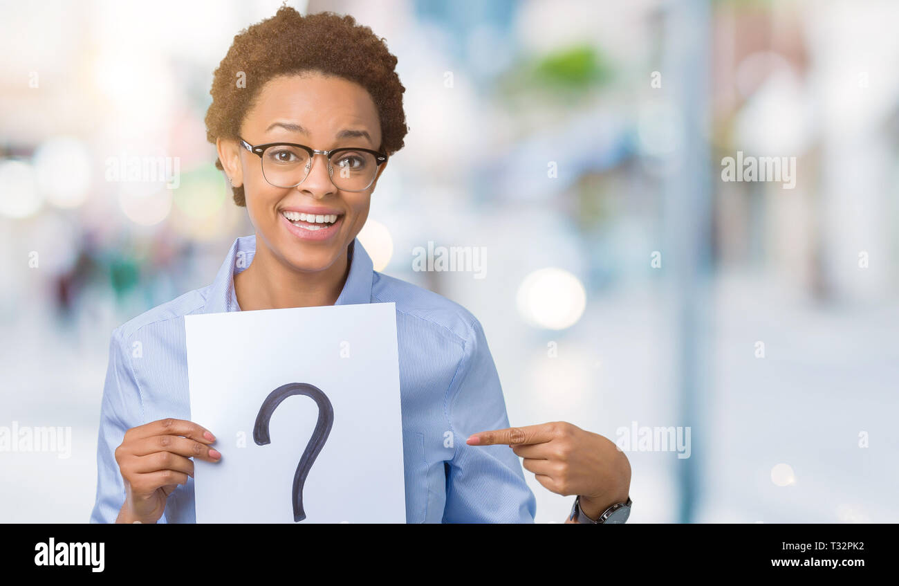 Young african american woman holding paper with question mark over ...